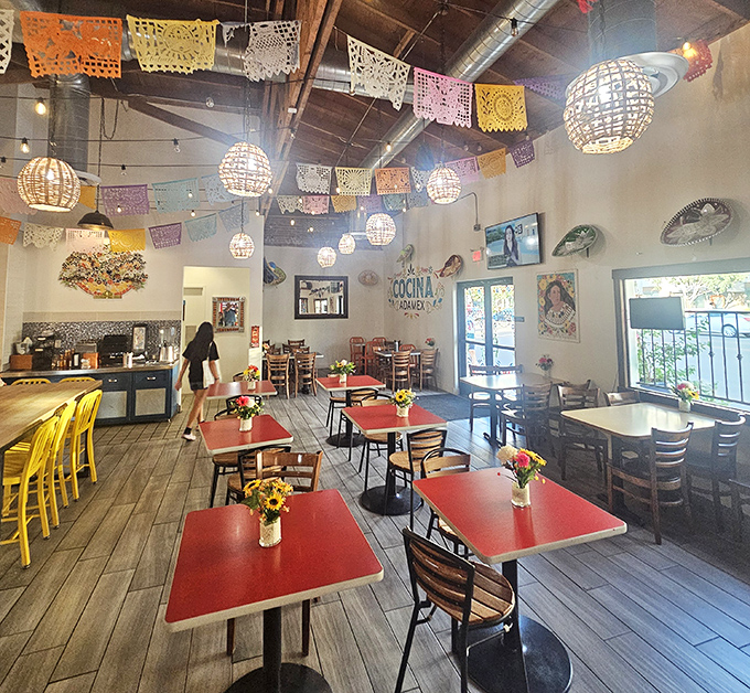 Red tables pop against wooden floors while colorful banners create a perpetual fiesta atmosphere – proving great design doesn't need a million-dollar budget.