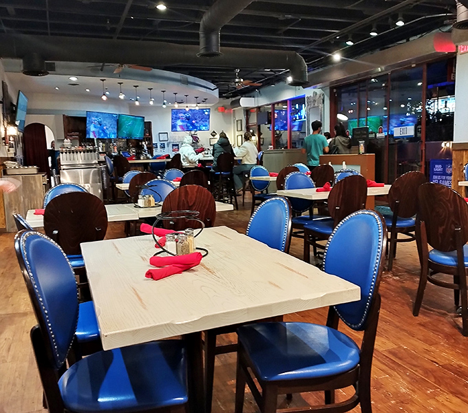 Modern meets rustic in this dining area where blue chairs pop against wooden tables. The perfect setting for the flavor explosion that's about to happen.