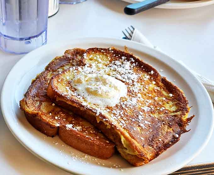 French toast that makes you question every other breakfast you've ever had &ndash; golden, crispy edges giving way to custardy centers dusted with powdered sugar snow.