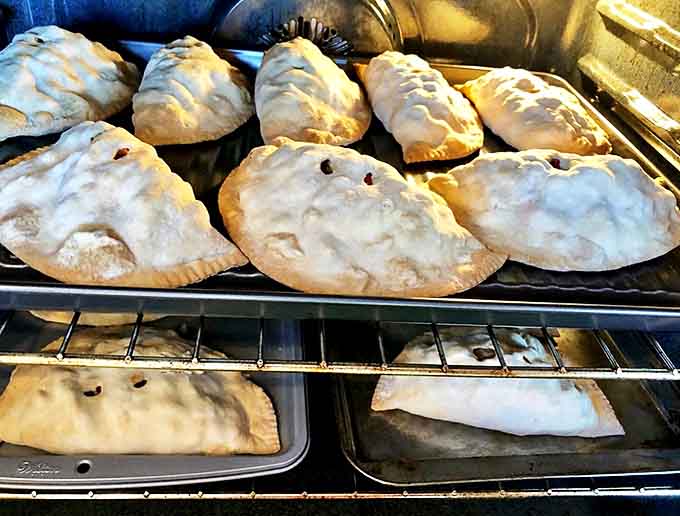 Fresh from the oven, these pasties showcase the distinctive crimped edges and steam vents that mark authentic Upper Peninsula craftsmanship.