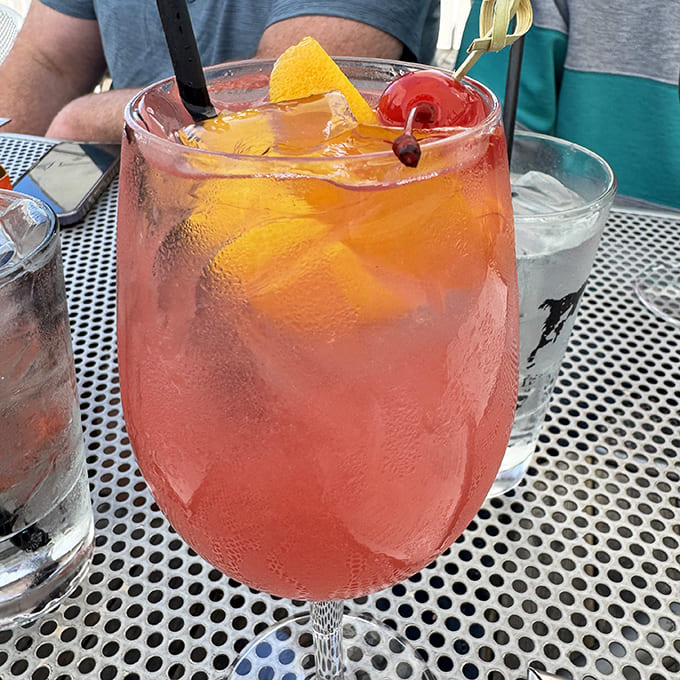 Summer in a glass! This rosy cocktail, garnished with citrus and cherries, promises refreshment with just enough kick to remind you you're on vacation.