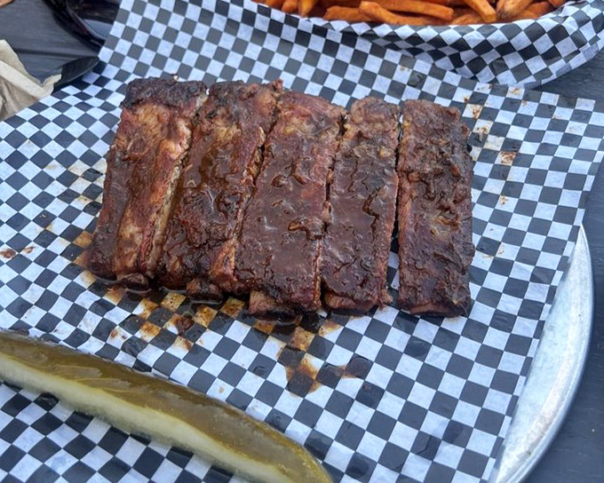 Fall-off-the-bone ribs with a perfect smoke ring &ndash; evidence of low and slow cooking that transforms tough meat into tender barbecue bliss.