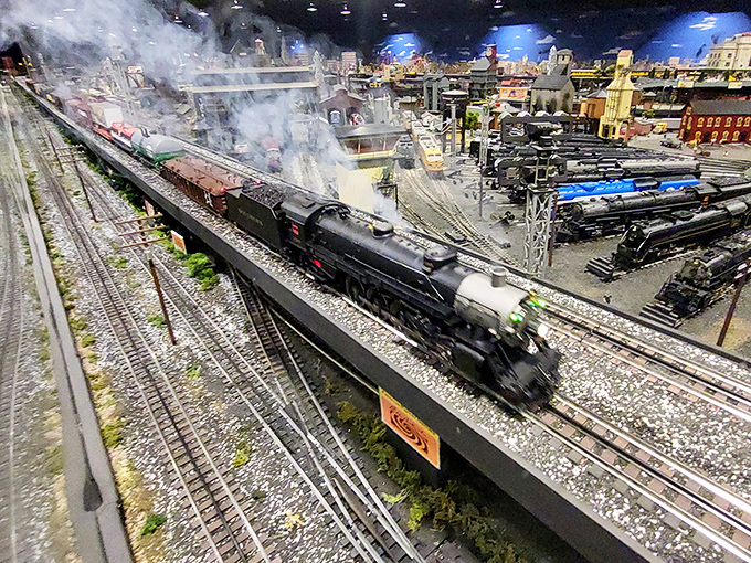 Steam billows dramatically as this locomotive thunders through a landscape where every pebble was placed with purpose.