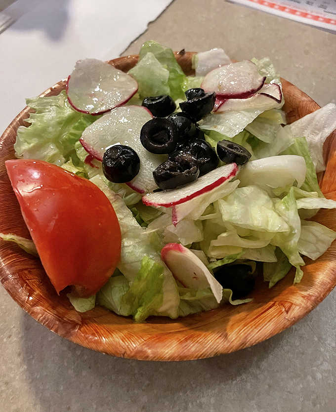 A simple salad in a wooden bowl &ndash; the token vegetable portion that makes everything else guilt-free.