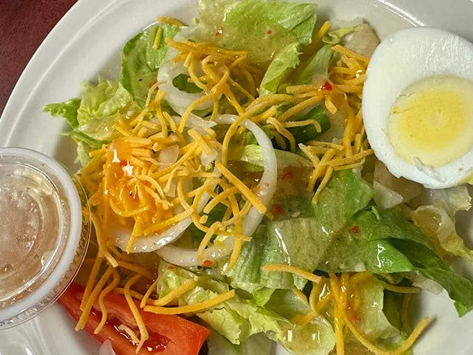 A side salad that actually tries &ndash; fresh greens, shredded cheese, and a hard-boiled egg that wasn't born during the last presidential administration.