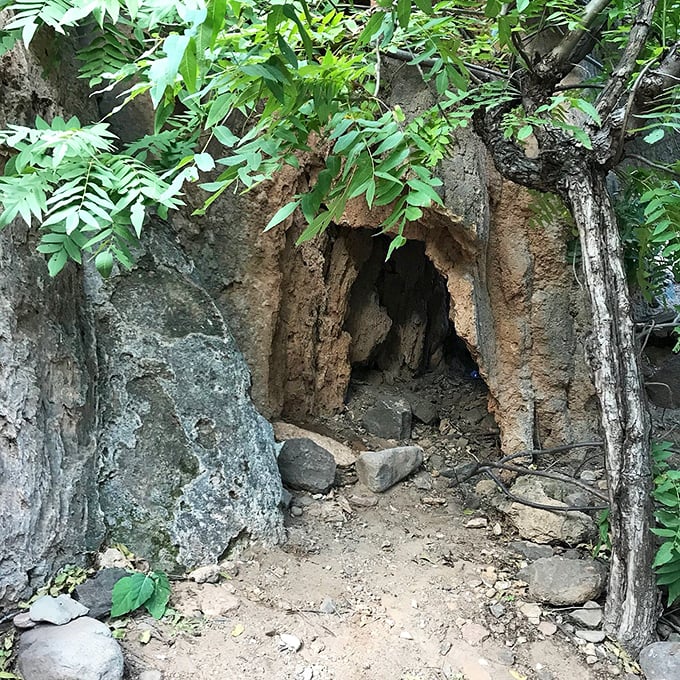 Small cave entrance beckons: Nature's own secret hideaway &ndash; a mysterious opening in the rock wall that whispers of ancient stories and cool refuge.
