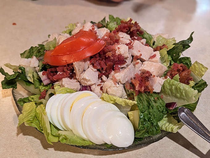The chicken salad arrives fresh and vibrant, with crisp romaine, hard-boiled eggs, and generous protein making it a meal in itself.