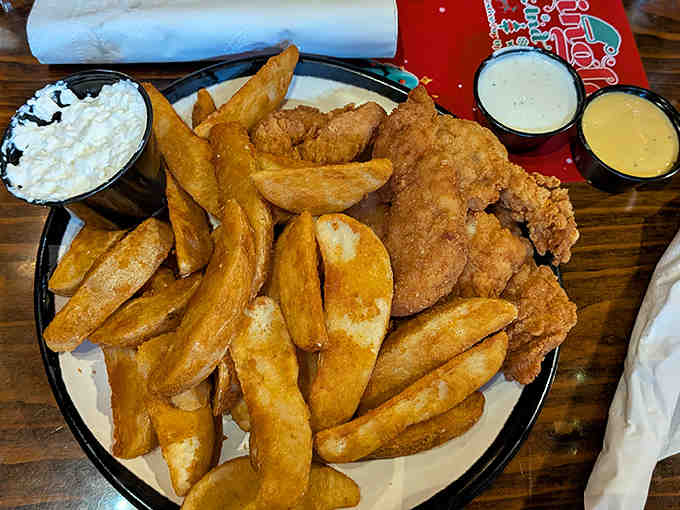 Fish and chips done right &ndash; crispy golden batter surrounding flaky white fish, with thick-cut fries and creamy coleslaw completing this classic plate.