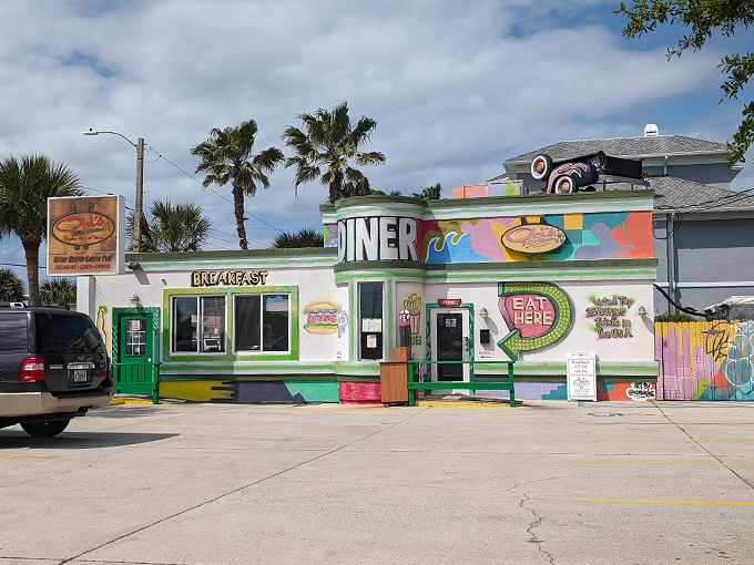 That bright green and white exterior isn't subtle, and neither are the burgers waiting inside this automotive-themed paradise.