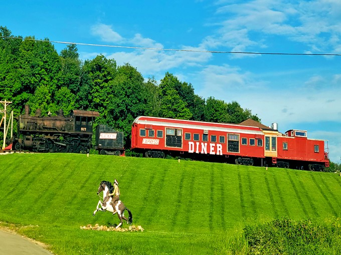 A vintage locomotive, bright red dining car, and caboose create an eye-catching roadside attraction that's impossible to miss from the highway.