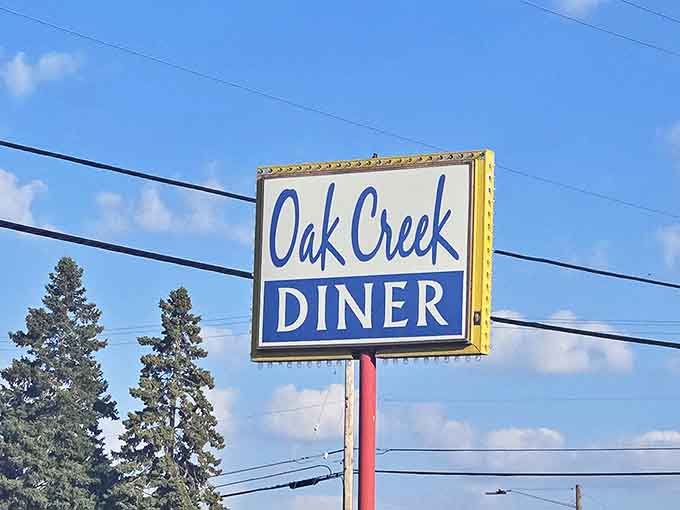 The iconic Oak Creek Diner sign stands as a beacon for hungry travelers and locals alike &ndash; a promise of good food ahead.