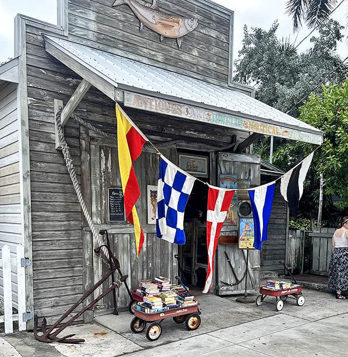Weather-beaten wooden facade with colorful nautical flags and a silver tarpon standing guard &ndash; Key West's most charming literary hideaway beckons adventurous souls.