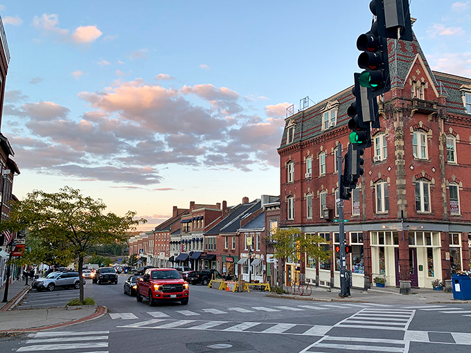 Belfast's historic downtown greets visitors with classic New England charm, red brick buildings cascading gently toward the shimmering harbor below.