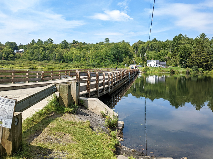 The Brookfield Floating Bridge stretches across Sunset Lake like a wooden walkway that decided to take a permanent bath.