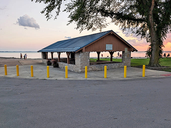 The rustic pavilion at Catawba Island State Park stands sentinel over Lake Erie, its weathered beams framing postcard-perfect sunset views for picnickers and dreamers alike.