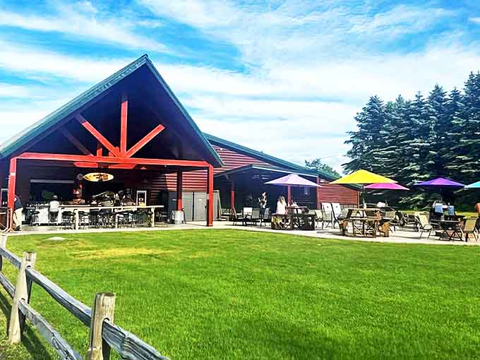 The rustic charm of Chase Creek Smokehouse welcomes hungry travelers with its distinctive log cabin exterior and inviting outdoor seating area.