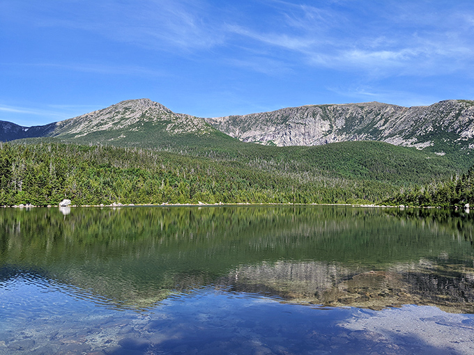 Mirror, mirror on the pond: Katahdin's majestic face creates nature's perfect reflection in crystal-clear alpine waters.