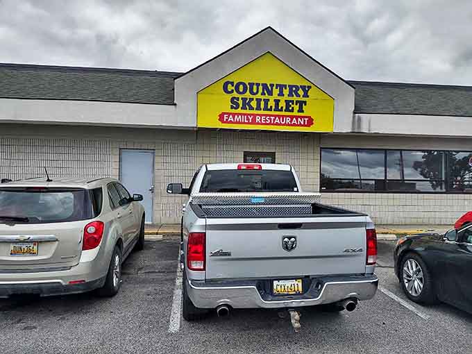 The bright yellow Country Skillet sign stands out against the Michigan sky, a beacon for hungry travelers seeking authentic diner fare.