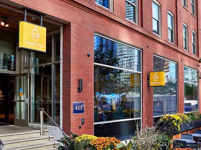 That cheerful yellow sign beckons like a breakfast beacon, promising croissants and coffee that'll make your morning infinitely better than it was five minutes ago.