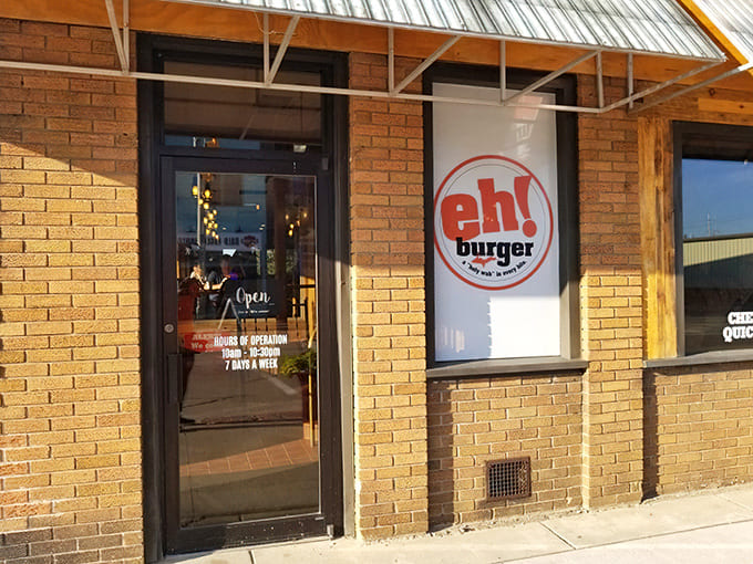 The unassuming brick facade of Eh! Burger beckons hungry travelers with its simple orange logo &ndash; a humble gateway to burger paradise.