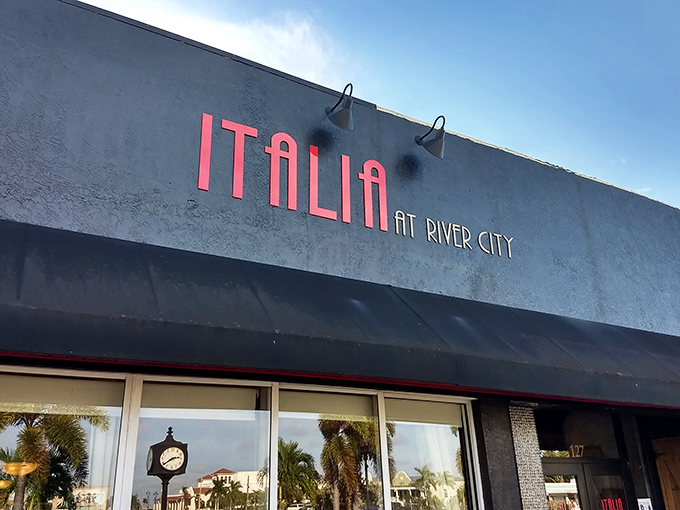 The bold red lettering of Italia at River City stands out against the gray exterior, like a delicious promise waiting to be fulfilled.