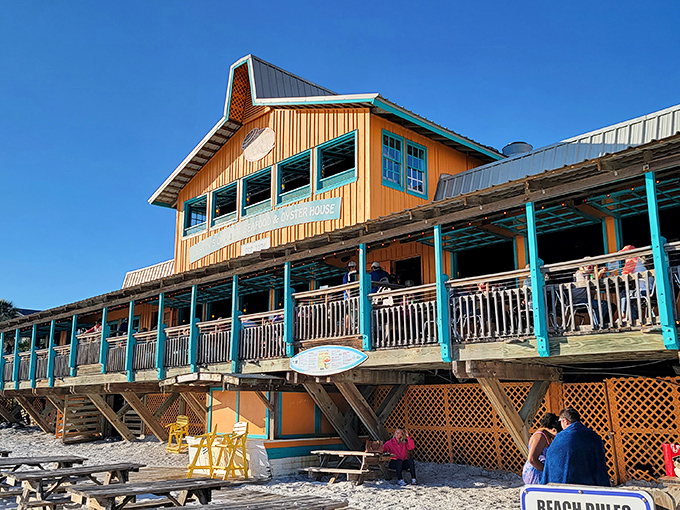 The Back Porch's weathered wooden exterior and turquoise trim create that perfect "I've discovered something special" feeling as you approach from the beach.