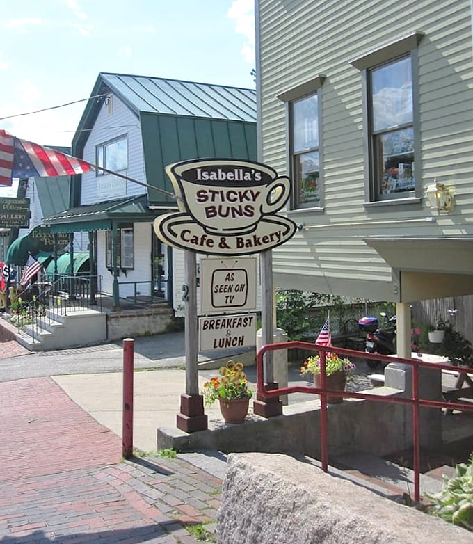 The charming exterior of Isabella's Sticky Buns beckons with its vintage sign and cozy entrance, promising sweet treasures within.