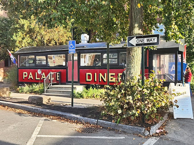 The crimson railcar gleams in the autumn light, its bold "PALACE DINER" lettering promising culinary time travel to anyone lucky enough to step inside.