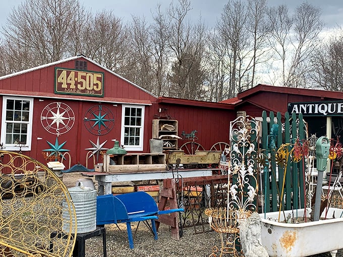 The iconic red exterior of Hobby Horse Antiques beckons treasure hunters with its weathered charm and nautical decorations spilling into the yard.