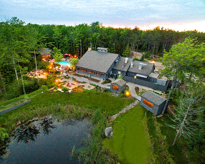 Welcome to Earth at Hidden Pond, where Mother Nature and fine dining have a passionate love affair. This aerial view showcases a culinary oasis nestled in Maine's lush forests.