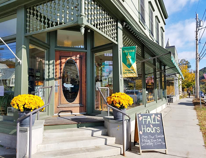 The welcoming facade of Barrister's Bookshop, with its vintage green exterior and cheerful yellow mums, beckons bibliophiles like a literary lighthouse in South Royalton.