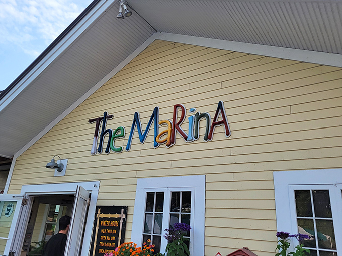 The cheerful yellow exterior of The Marina welcomes visitors with its colorful, playful signage &ndash; a sunny prelude to the waterfront dining experience that awaits inside.