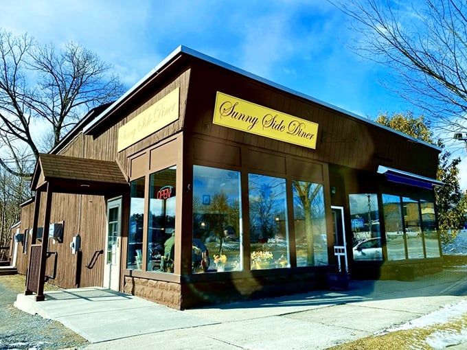 Sunny Side Diner's rustic wooden exterior promises breakfast treasures within. That yellow sign might as well read "Pancake Paradise Ahead!"