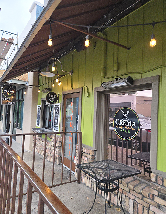 The vibrant lime-green exterior of Crema beckons hungry visitors with its charming string lights and inviting patio seating.