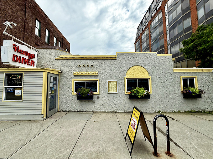 The iconic white stucco exterior and glowing red sign of Henry's Diner stands as a beacon of comfort food in downtown Burlington.