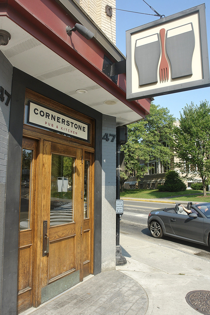 Cornerstone's welcoming entrance beckons with warm wooden doors and that iconic fork-and-glasses sign &ndash; Vermont hospitality at its finest.