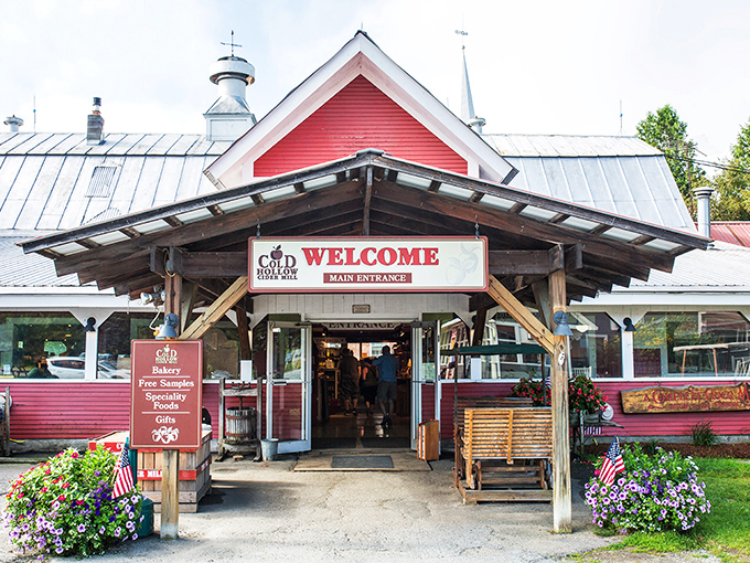 The iconic red barn of Cold Hollow Cider Mill welcomes visitors with its charming Vermont character and promises of apple-filled delights inside.