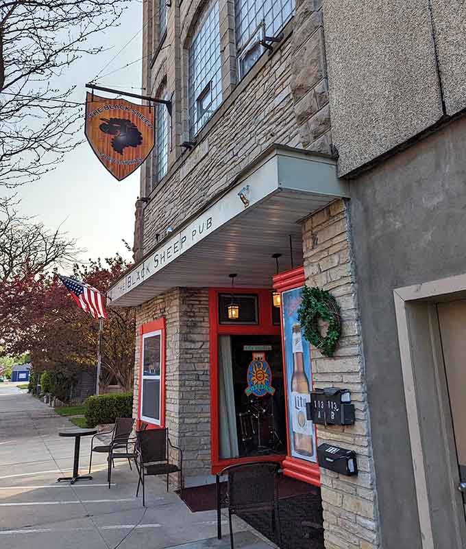 The welcoming facade of Black Sheep Pub stands out with its stone exterior and distinctive red trim, beckoning hungry travelers inside.