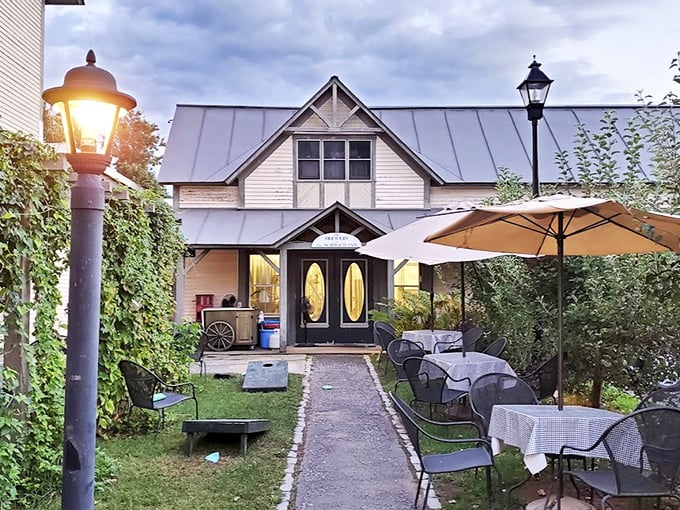 A charming New England ale house beckons with warm golden light and inviting outdoor seating, like a cozy friend's house that happens to serve amazing food.