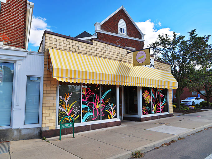 Exterior: Butter Cafe's cheerful yellow awning and vibrant window art beckon breakfast enthusiasts like a colorful beacon of morning promise.
