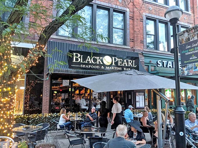 The Black Pearl's inviting exterior beckons passersby with twinkling lights and outdoor seating &ndash; Ann Arbor's seafood sanctuary awaits discovery.