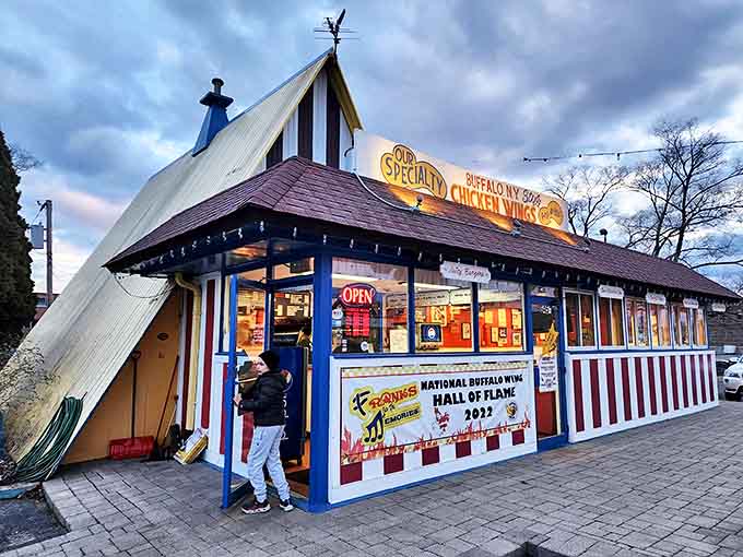 The iconic A-frame building stands like a shrine to wing perfection, its red, white, and blue exterior promising saucy delights within.