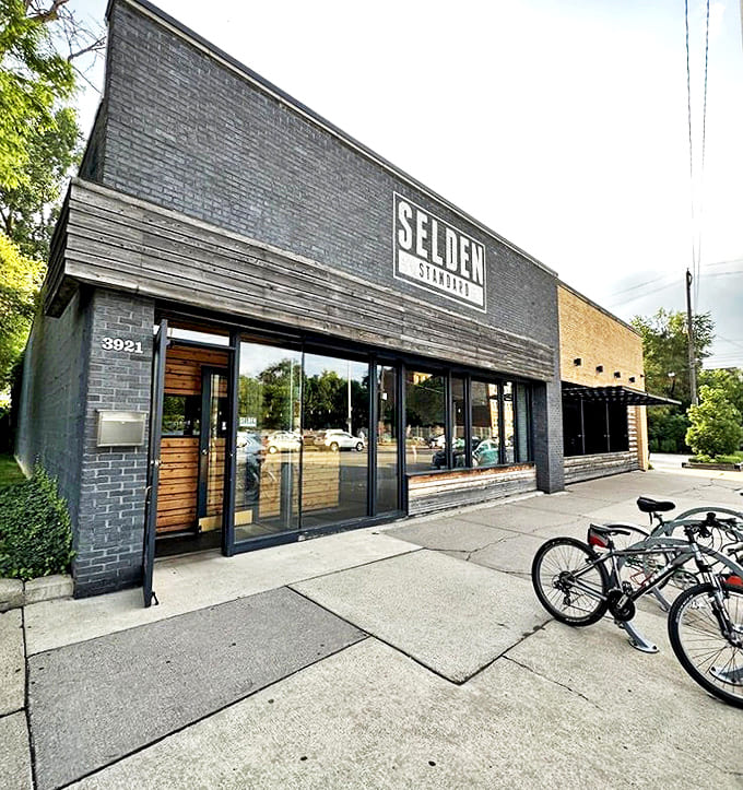 Exterior: A sleek black brick building stands confidently on the street, its understated signage promising culinary adventures within. Bicycles parked outside hint at local popularity.