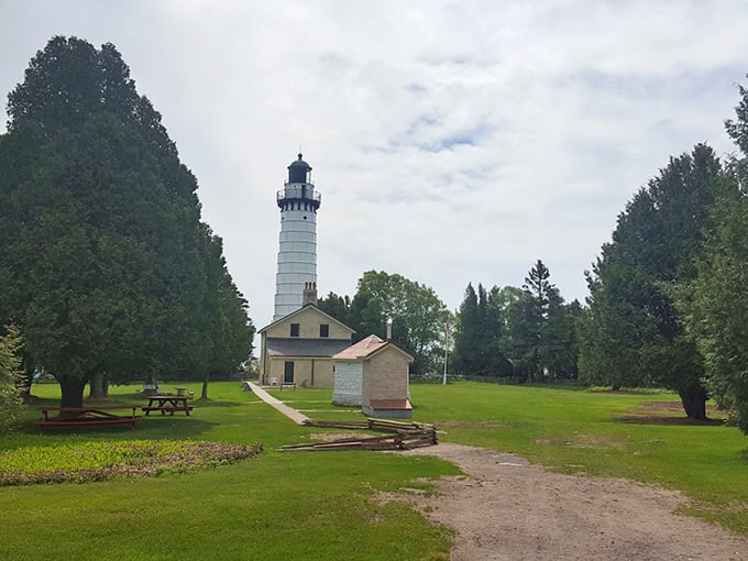 The iconic white tower of Cana Island Lighthouse stands tall against the Wisconsin sky, a beacon of maritime history since 1869.