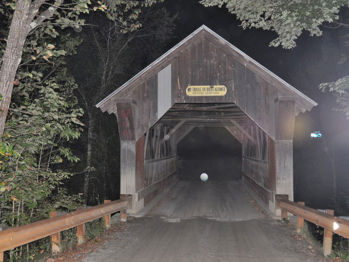 Gold Brook Covered Bridge stands sentinel in the darkness, its weathered frame harboring secrets and perhaps something more sinister than memories.