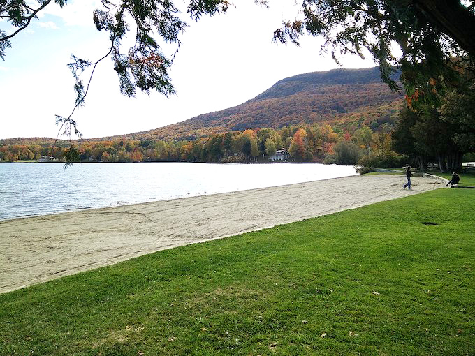 A sandy beach meets crystal-clear waters at Green River Reservoir, where mountains create nature's perfect backdrop for an afternoon escape.