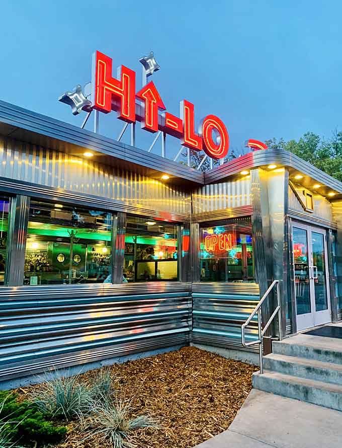 That neon sign glowing like a beacon for breakfast lovers everywhere, calling you home to the chrome-wrapped temple of Huevos Rancheros perfection.