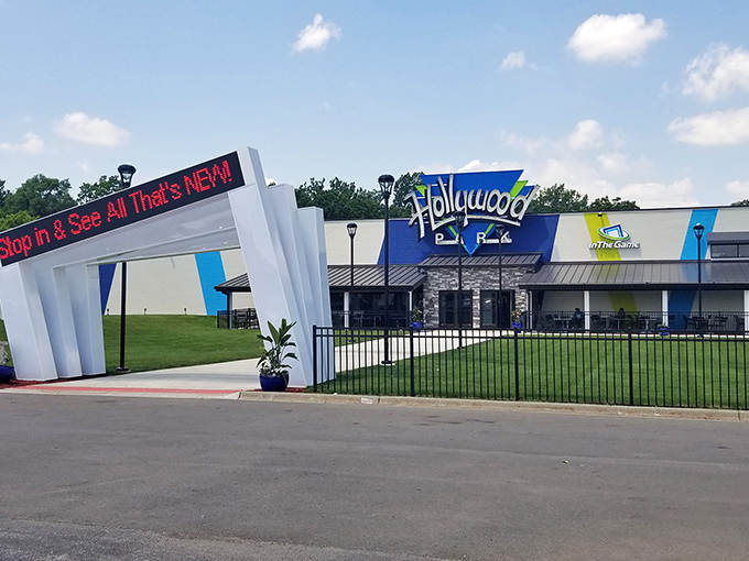 The vibrant blue and white facade welcomes visitors with its grand entrance arch, promising adventures that await just beyond those doors.