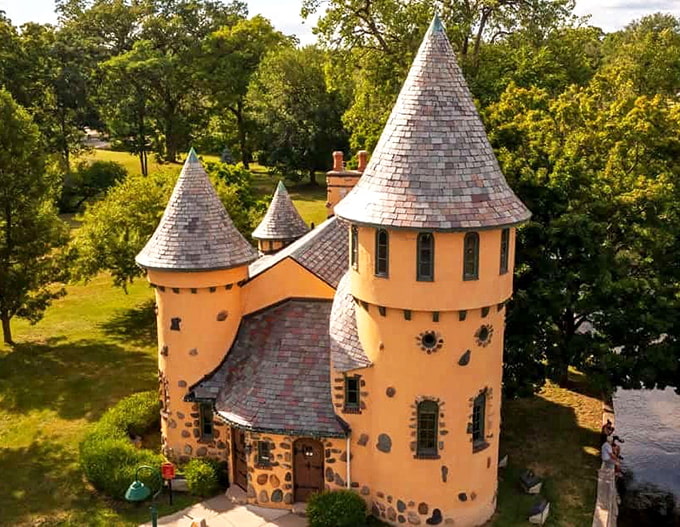 Curwood Castle rises like a golden fairytale from the Michigan landscape, its distinctive turrets reaching skyward along the peaceful Shiawassee River.