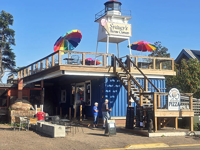 That lighthouse tower isn't just for show, it's your beacon to some of the best pizza on Lake Superior's shore, complete with rainbow umbrellas that practically scream summer fun.